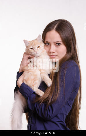 Portrait d'une jeune fille rousse avec un chat rouge en plein air, sur ...