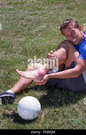 Jeune homme tenant sa cheville enflée hurlant de douleur après le ...