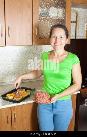 Femme faisant de boeuf farcies dans sa cuisine. L'une des étapes de ...