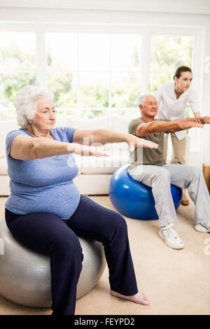 Physiothérapeute aider les patients avec des exercices Photo Stock - Alamy