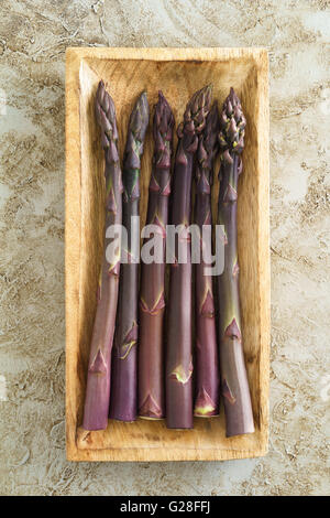 asperges fraîches dans un bol en bois isolé sur fond blanc. Vue de ...