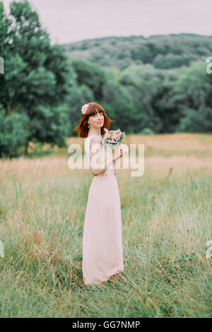 Portrait de rousse charmante épouse modèle avec bouquet de mariage à la ...