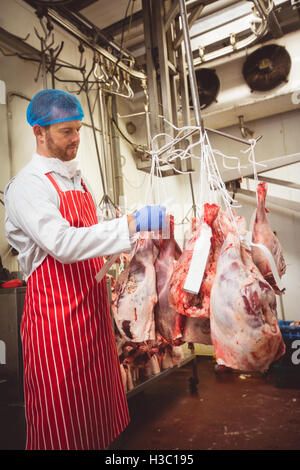 Butcher coller étiquettes codes barres sur la viande rouge dans la ...