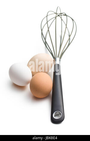 Trois oeufs et mélanger au fouet ou batteur à oeufs sur fond de bois ...