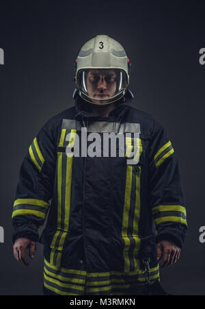 Pompier professionnel en uniforme portant un casque de protection et ...