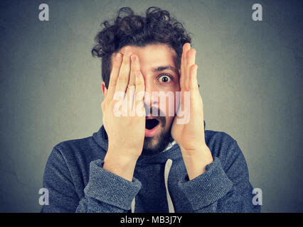 Jeune homme hipster peur et choqué par l'expression de surprise, la ...