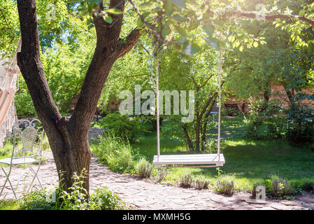 Balançoire en bois sur corde et hamac sous le grand arbre du jardin ...