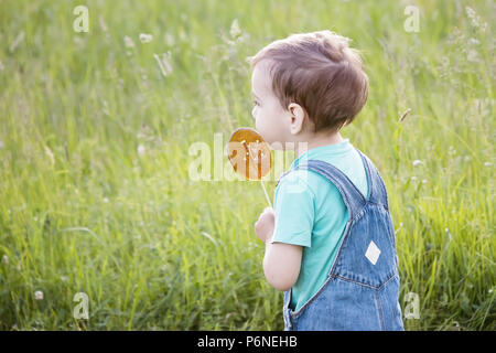 Bébé garçon avec un suçon sur sa baguette dans ses mains marchant le ...