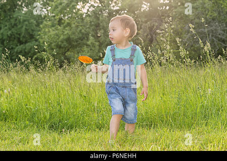Bébé garçon avec un suçon sur sa baguette dans ses mains marchant le ...