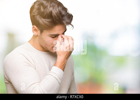 Beau jeune adolescent hispanique frottant les yeux qui démangent sur la rue de la ville éclairée ...