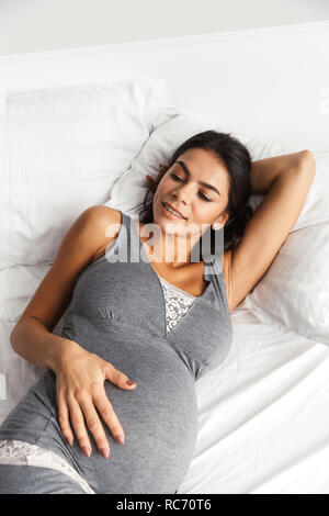 Une femme enceinte se trouve à la maison sur un canapé bleu dans des ...