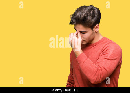 Beau jeune adolescent hispanique frottant les yeux qui démangent sur la rue de la ville éclairée ...