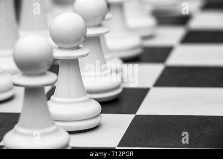 Les échecs, l'un pion noir se trouve en face d'un groupe de pions ...