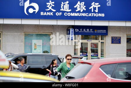 --File--piétons passent par une succursale de Bank of Communications ...