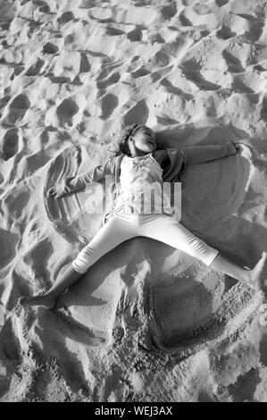 Girl lying on sand sable rendre angel, high angle view Photo Stock - Alamy