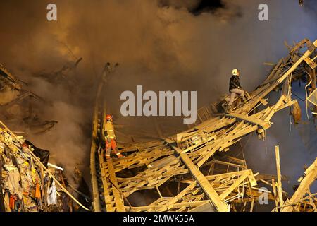 Iranian firefighters work at the scene of the collapsed Plasco building ...