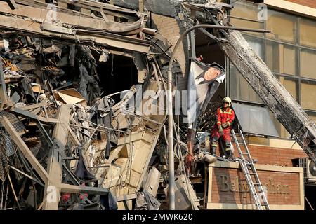 Iranian firefighters work at the scene of the collapsed Plasco building ...