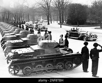 German Chancellor Adolf Hitler passes a saluting tank detachment lined ...