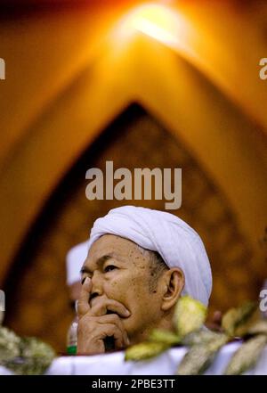 Opposition spiritual leader Nik Aziz Nik Mat, right, shares a light ...