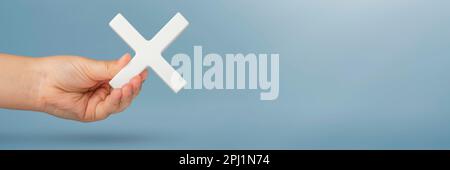Simbolo di moltiplicazione bianco o croce in mano. Il concetto di ...