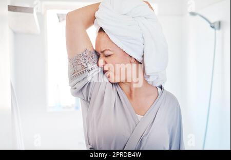 Giovane donna con cattivo odore di ascelle che utilizza deodorante a ...