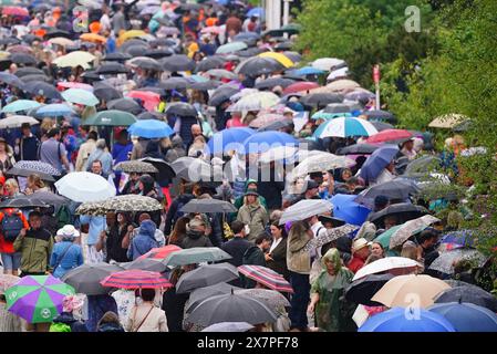 Gli ospiti si riparano sotto gli ombrelli mentre piove durante lo ...