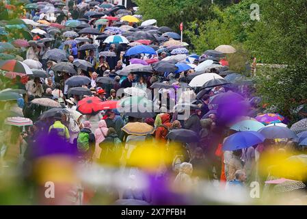 Gli ospiti si riparano sotto gli ombrelli mentre piove durante lo ...