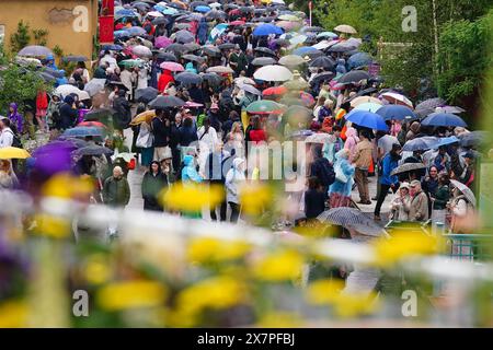 Gli ospiti si riparano sotto gli ombrelli mentre piove durante lo ...