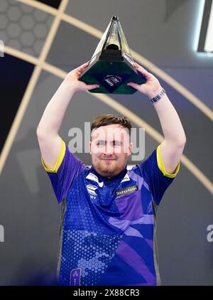 Luke Littler festeggia con il trofeo dopo la vittoria in finale contro ...