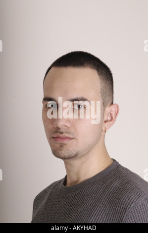 Ritratto di un uomo con la testa rasata, un anello di naso e una lunga ...