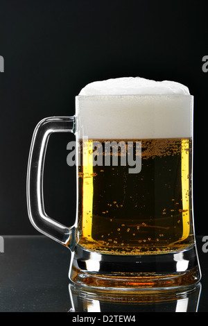 Boccale di birra con la schiuma su sfondo nero Foto stock - Alamy