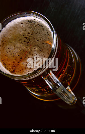 Boccale di birra con la schiuma su sfondo nero Foto stock - Alamy