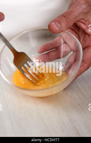 Battere l'uovo con una forchetta. Rendendo il pollo, formaggio e porri ...