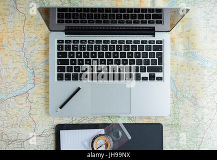 Computer portatile,cartina e bussola e un blocco note Foto stock - Alamy