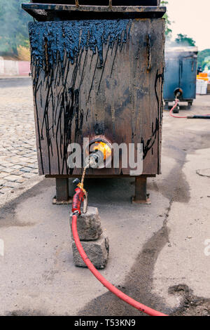 Versando passo fuso da un secchio di catrame. Passo tradizionale per ...
